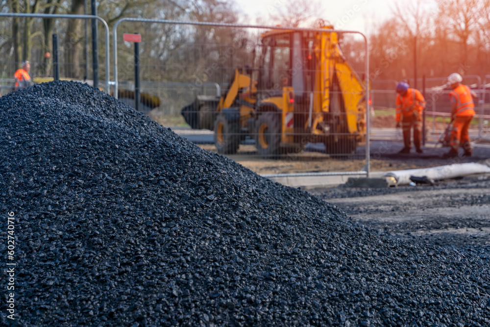 Fotka „Asphalt paver filled with hot tarmac laying new road surface on ...