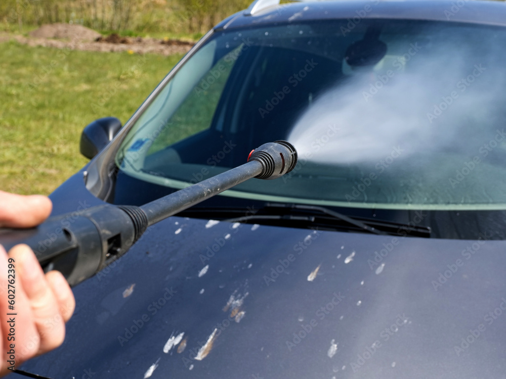 Karcher. A man washes his car with a high pressure Karcher in the open ...