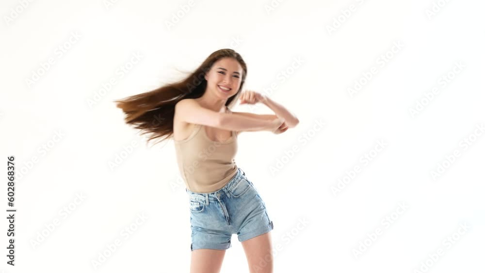 Pretty mixed race woman dancing modern dance on white wall background ...