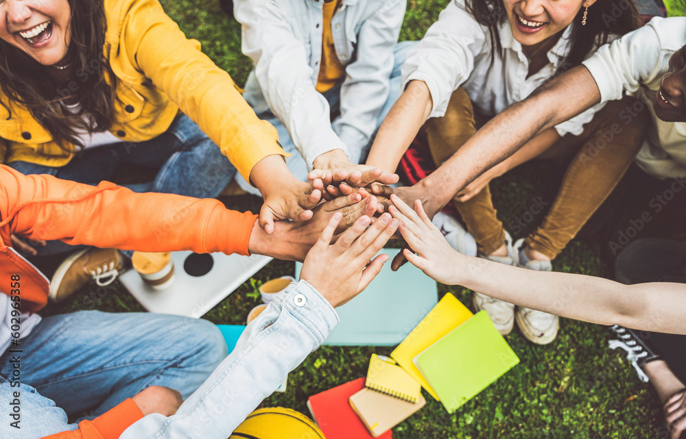 Multicultural university students stacking hands together in college ...