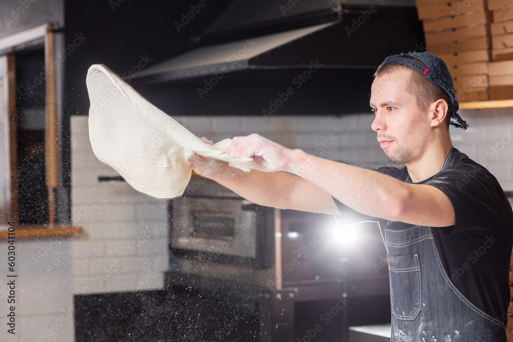 Dough for pizza, the chef rolls out the blanks. Closeup hand of chef ...