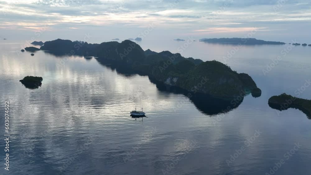 At sunrise, calm seas surround limestone islands that rise from Raja ...