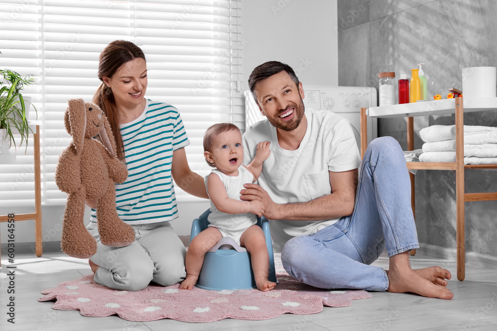 Parents training their child to sit on baby potty indoors Stock Photo ...