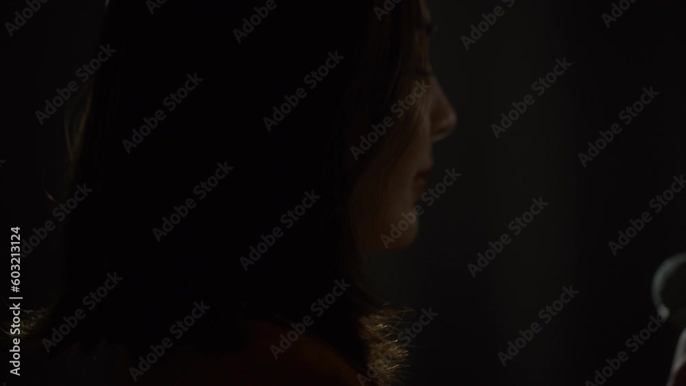 Back view Attractive singer woman singing music on stage with spotlight ...