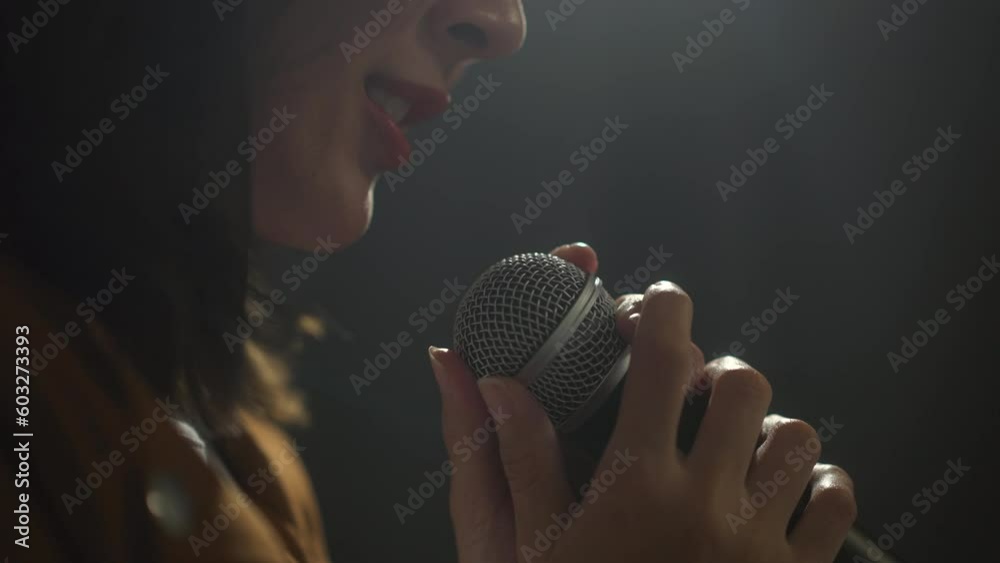 Side view Attractive singer woman singing music on stage with spotlight ...