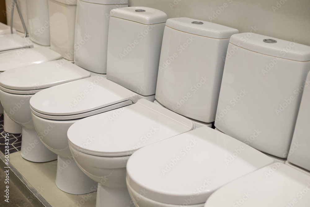 Ceramic toilet bowls of different types on a shop window. Sale of ...
