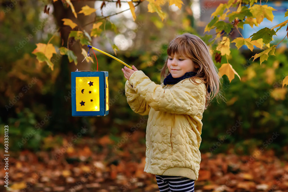 Little preschool kid girl holding selfmade traditional lanterns with ...