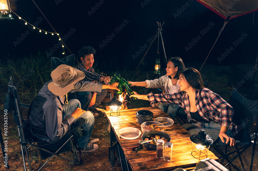 Asian LGBTQ+ couple drinking and barbecue in a romantic camping setting ...