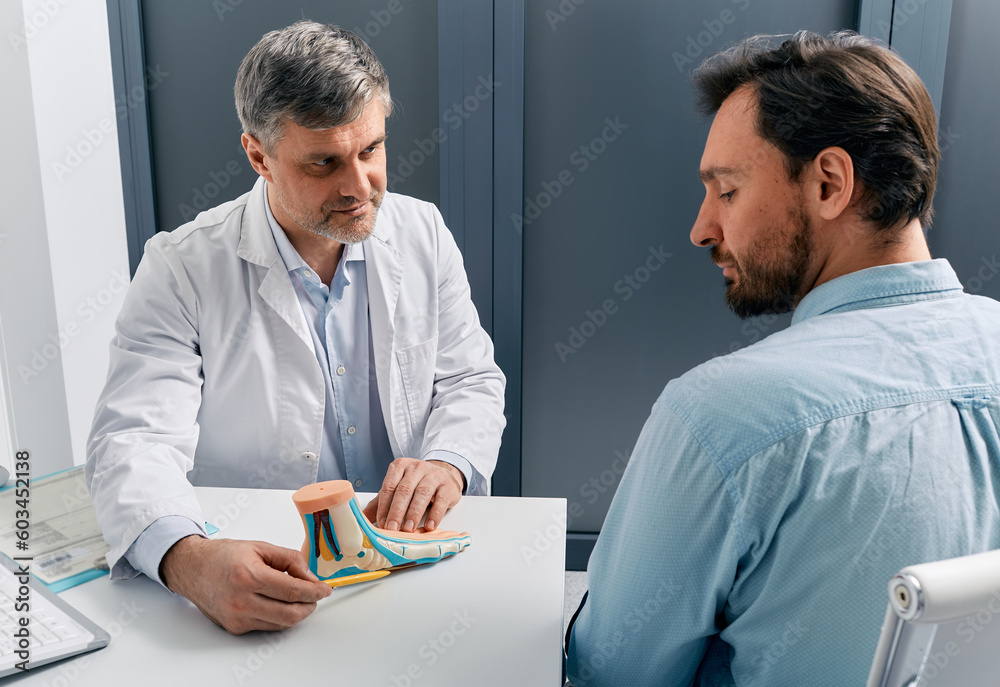 Flat feet treatment. Podiatrist doctor consulting adult man with ...