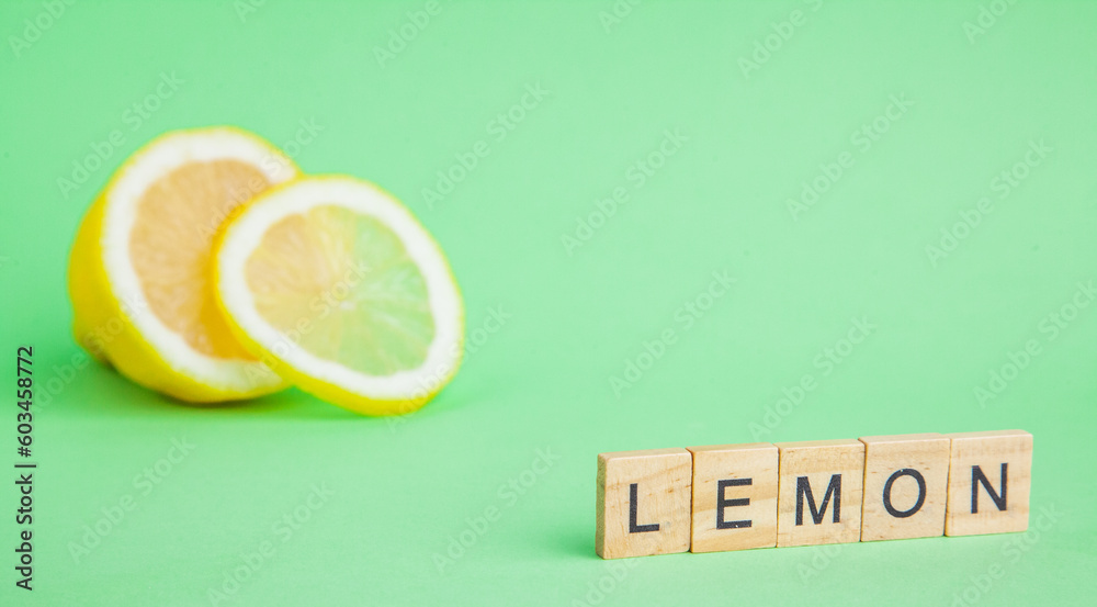 Medio limón con una loncha de limón junto a unas letras de madera Stock ...