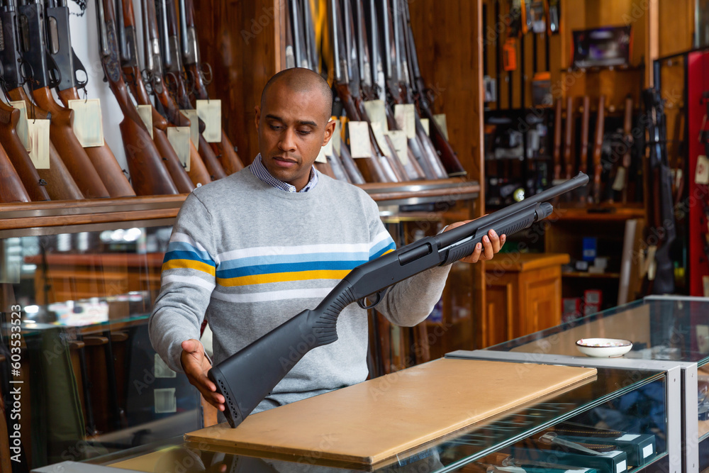 Gun shop salesman demonstrates a pump action shotgun Stock Photo ...
