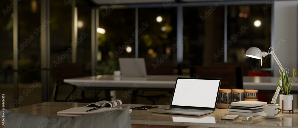 Workspace at night with laptop mockup, table lamp, and accessories on a ...