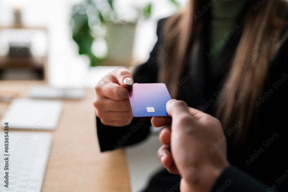 Unrecognizable male sharing credit card with anonymous female colleague ...