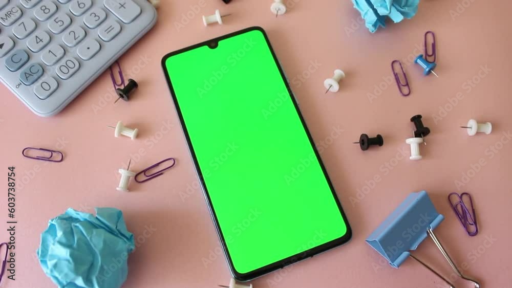 Top view, Smart phone on pink background with green screen and office ...