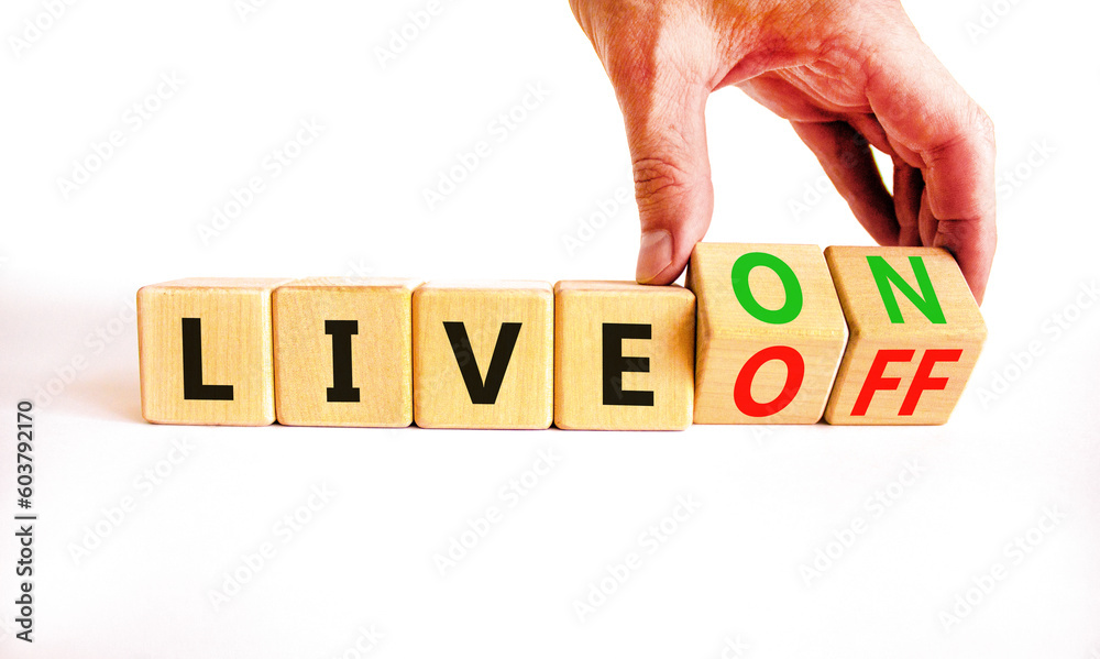 Live on or off symbol. Businessman turns wooden cubes and changes word ...