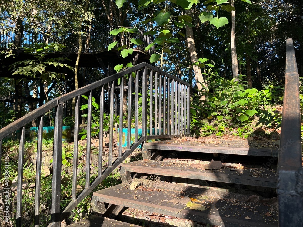 Long stair steps in the city park leading up a hill with metal railing ...