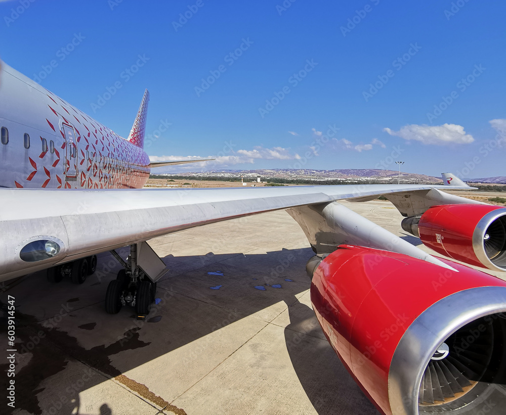Two red aircraft engines on the wing of an airplane standing in Paphos ...