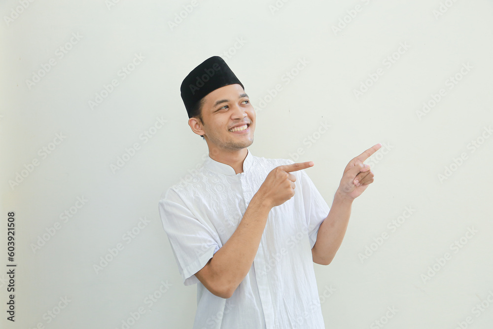 Smiling friendly young Asian Muslim man showing his hand recommends ...