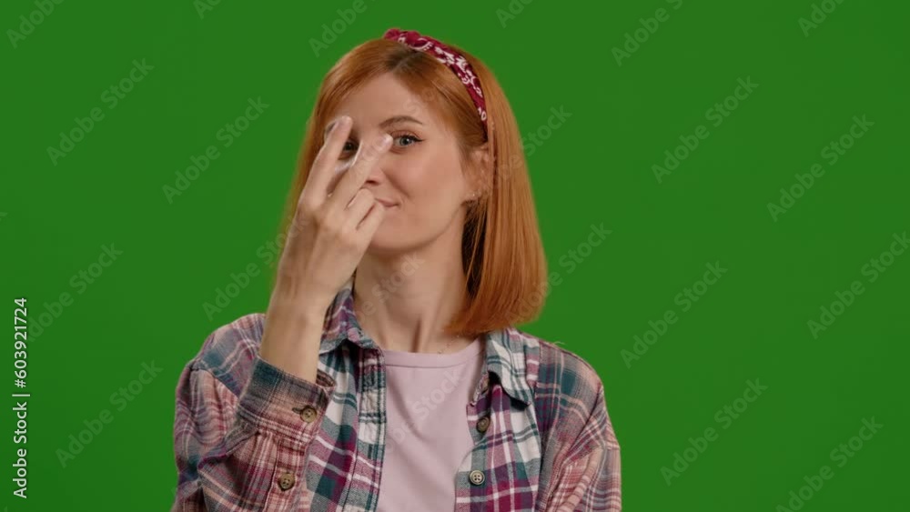 I am watching you gesture shown by Caucasian woman pointing at her eyes ...