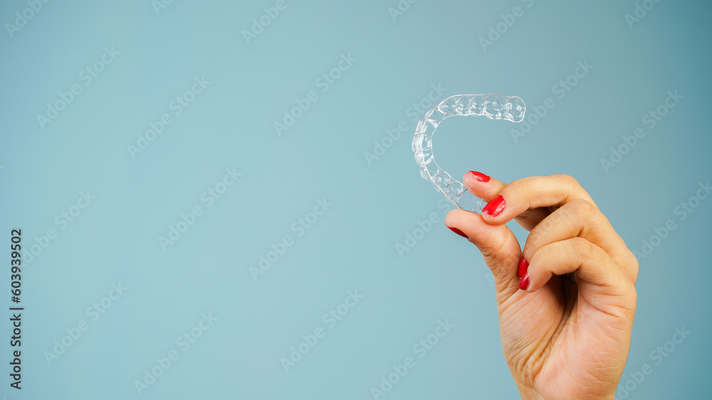 Young Asian Indian woman holding removable invisible aligner, also ...