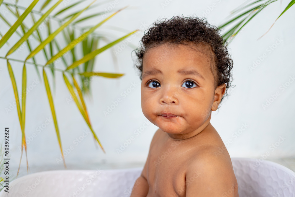 cute African baby bathing in the bath at home, concept of care and ...