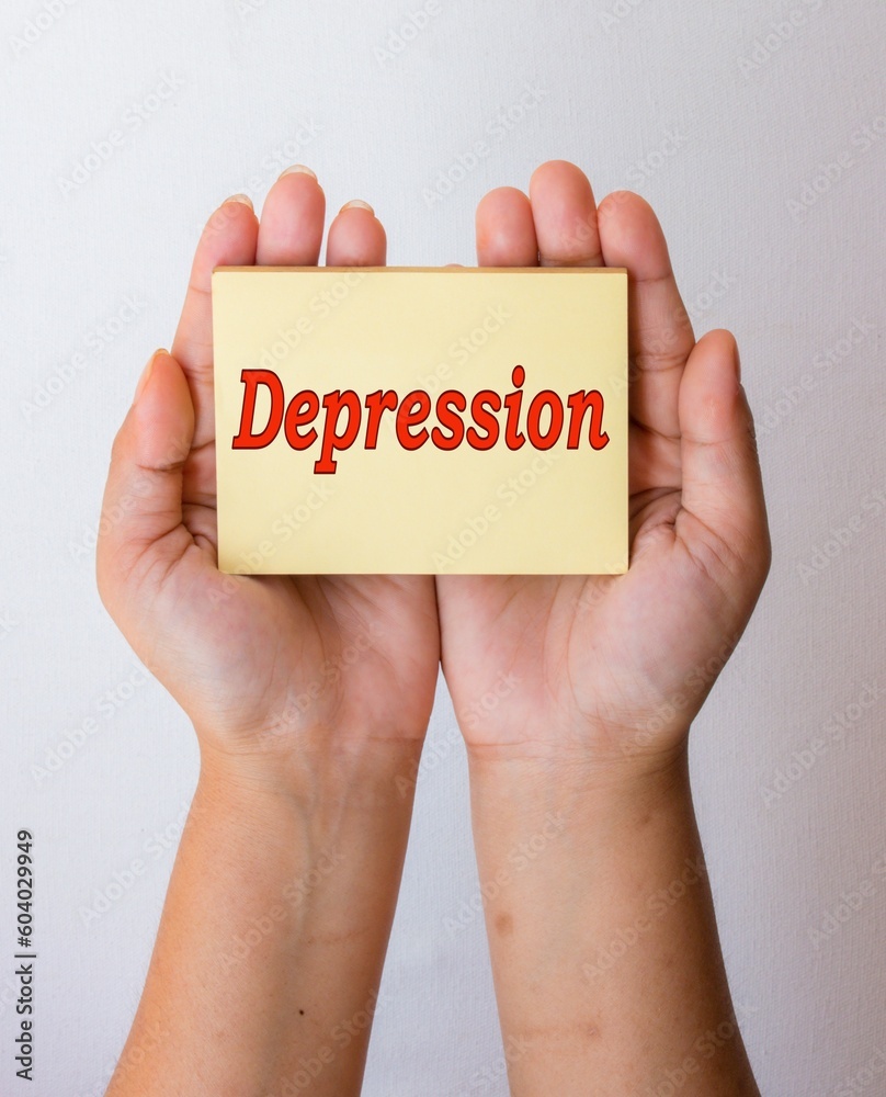 Hand holding depression text or word on yellow background note paper ...