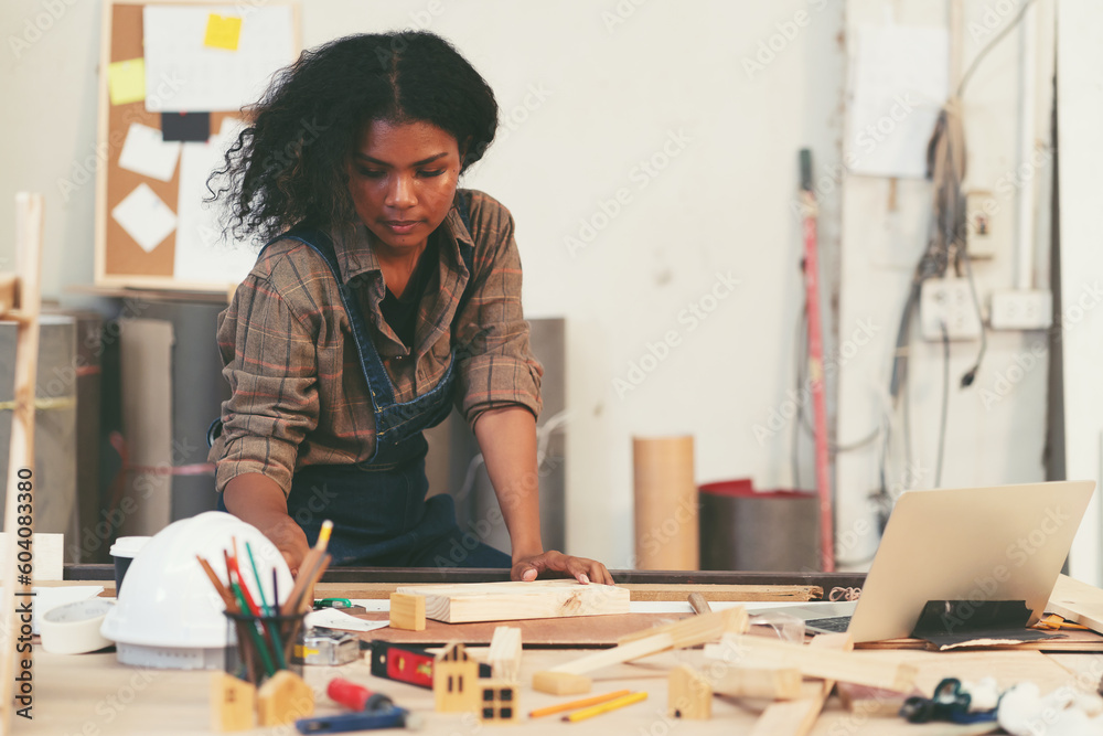 Female carpenter working with laptop computer and contact to customer ...