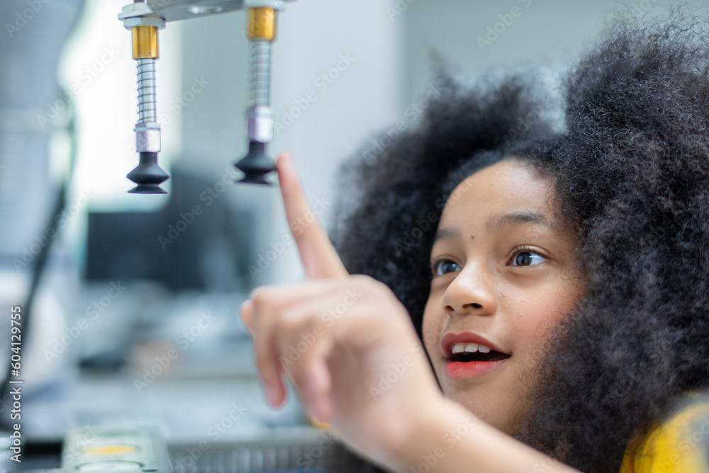 Kid female teen child enjoy Machine Learning Robot arm is Moving Under Control robot at ...