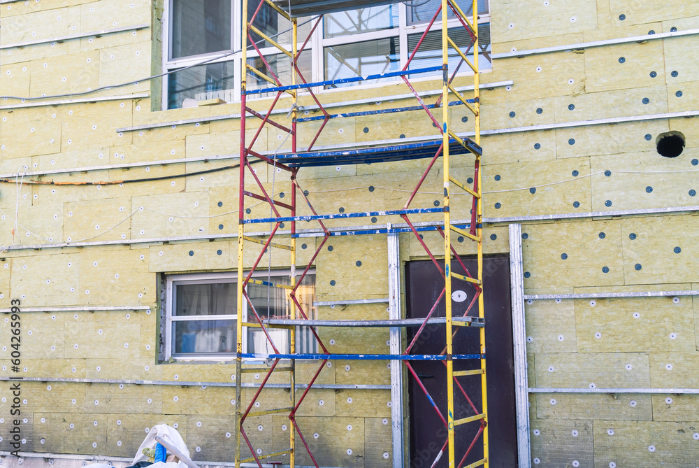 Installation of insulation on the exterior walls of the building. Metal ...