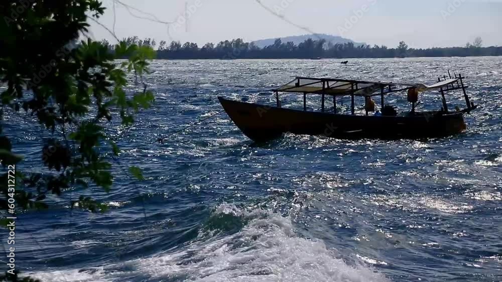 Violent waves in the sea tossing an anchored Khmer fishing boat during ...