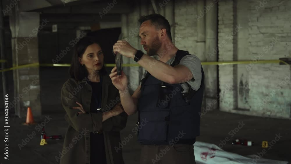 Medium full shot of Caucasian male and female police detectives ...