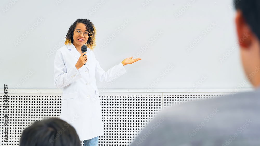 Female lecturer giving a lecture in the auditorium. University ...