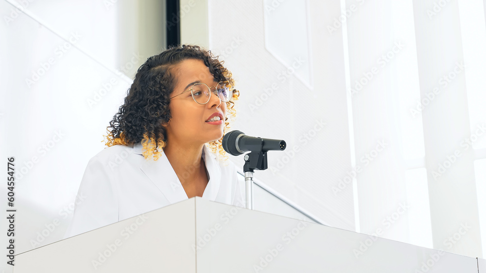 Female lecturer giving a lecture in the auditorium. University ...
