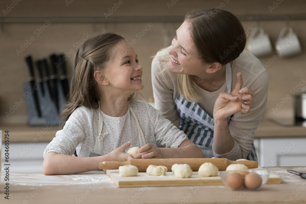 Mom smears with flour her little daughter nose, smile while cook ...