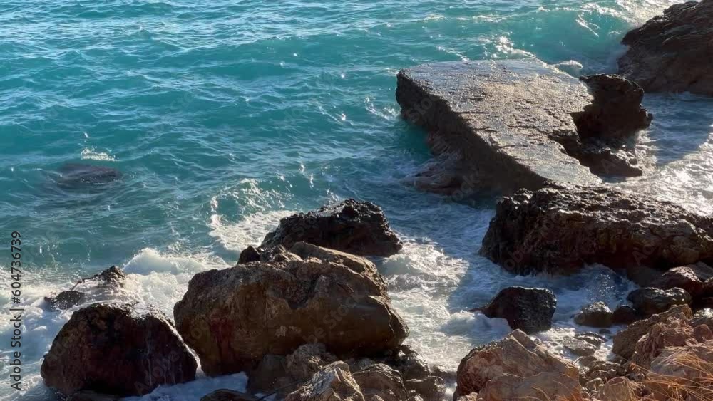 Boulders and rippling ocean waves. White foamy sea waves crash on beach ...