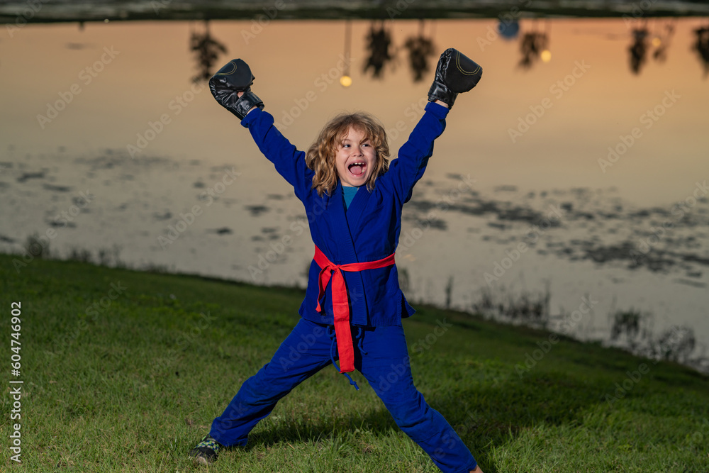 Excited little karate fighter. Kid boy practicing karate outdoor. Sport ...