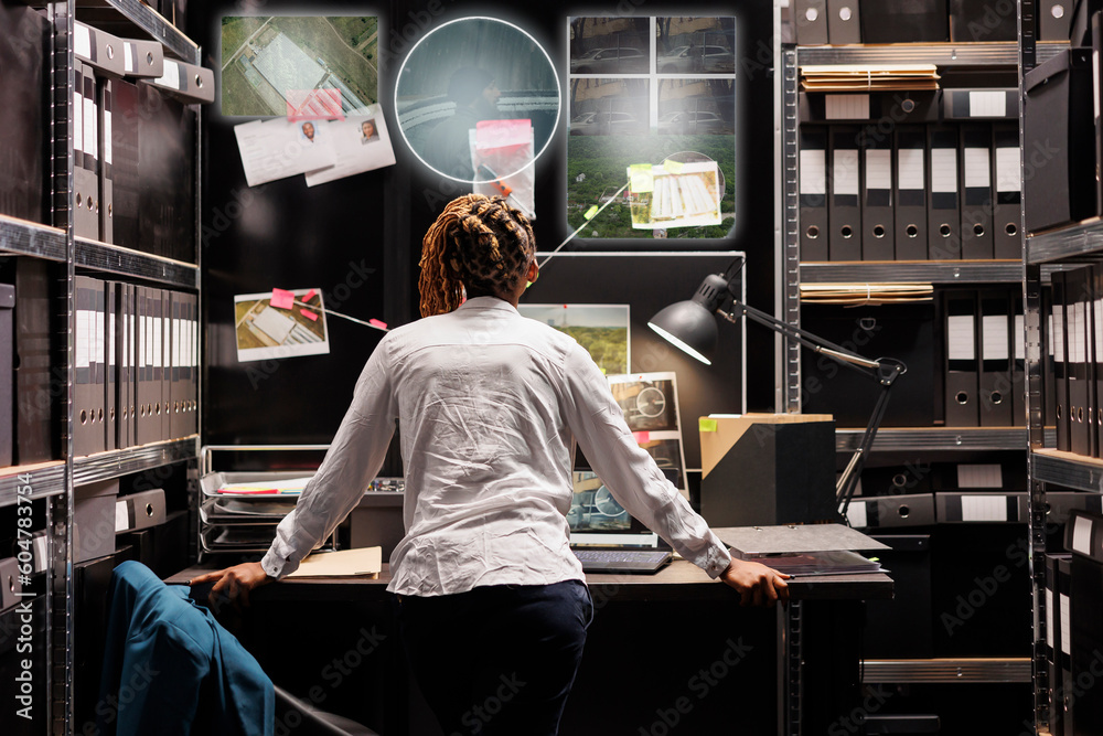 Young detective looking at hologram in incident room, trying to solve ...