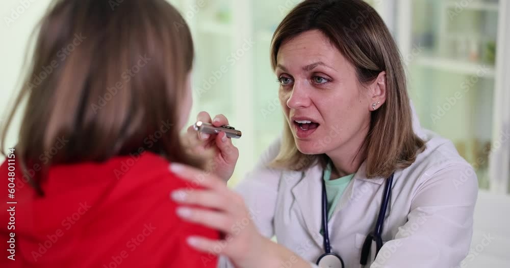 Otorhinolaryngologist examines girl with sore throat. Pharyngitis in ...
