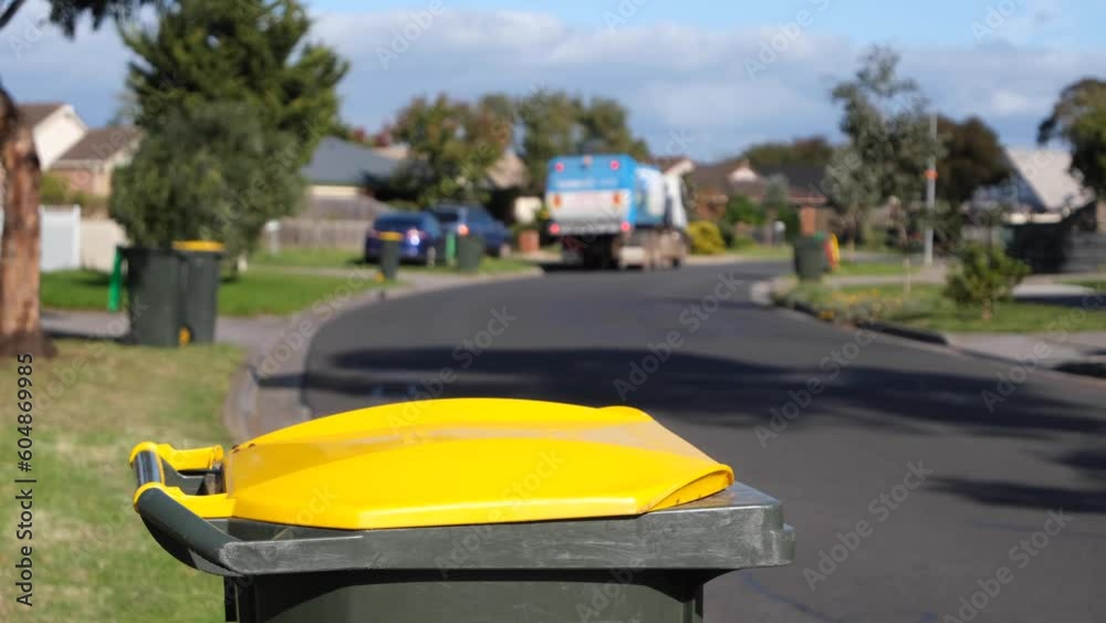 Close up of yellow lid of a rubbish bin with a blurry background of ...