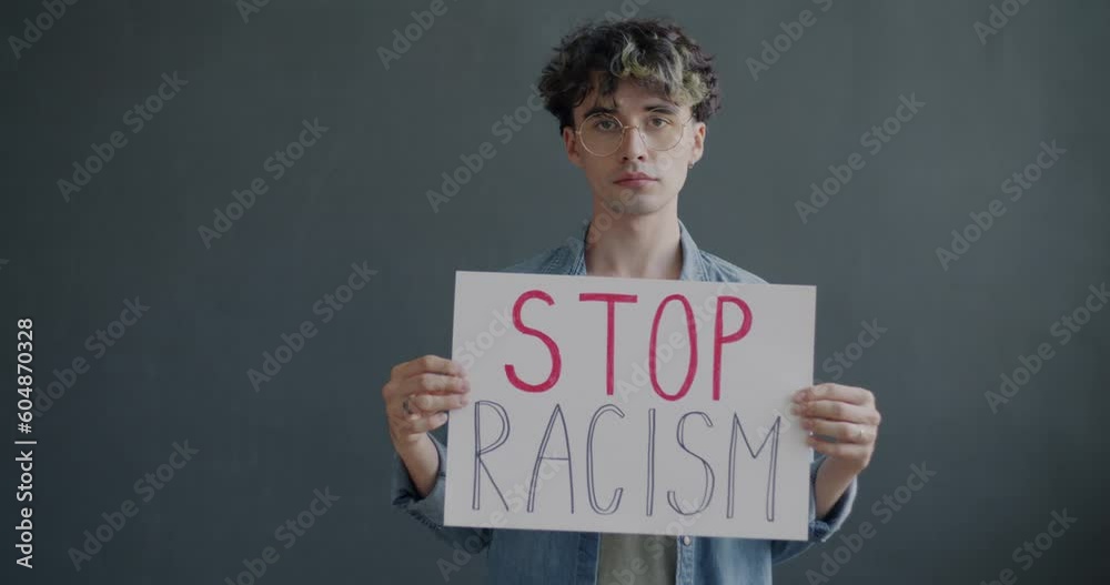 Portrait of social activist holding Stop Racism banner fighting racial ...