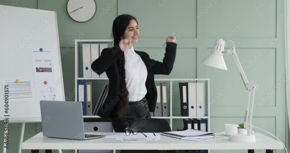 Young Indian woman as she dances with exuberance in office. Radiating ...