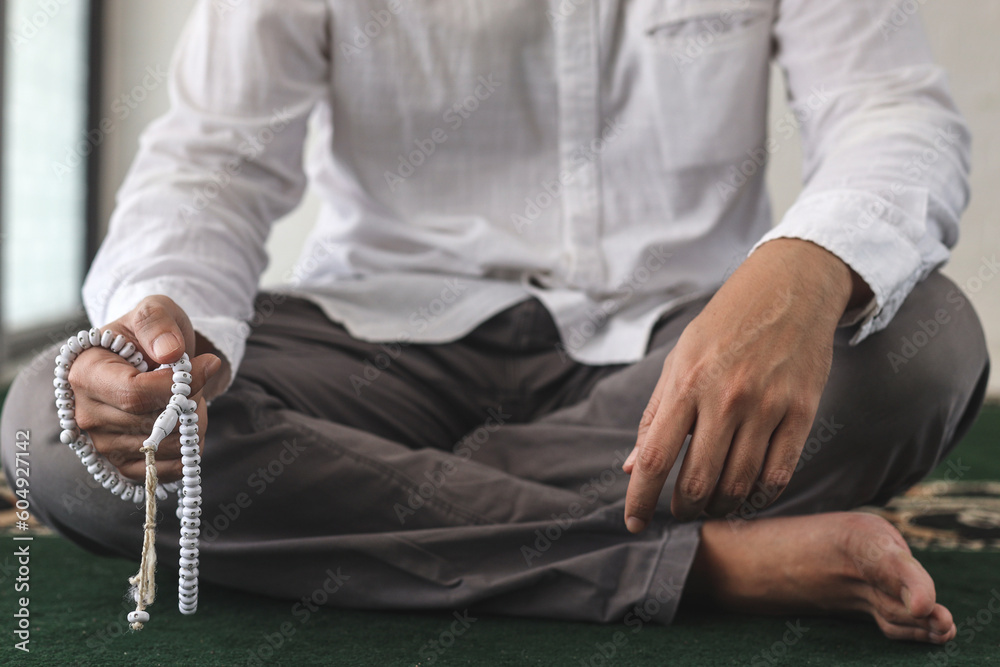 Foto de Hand and crossed legs of Muslim man praying in mosque ...