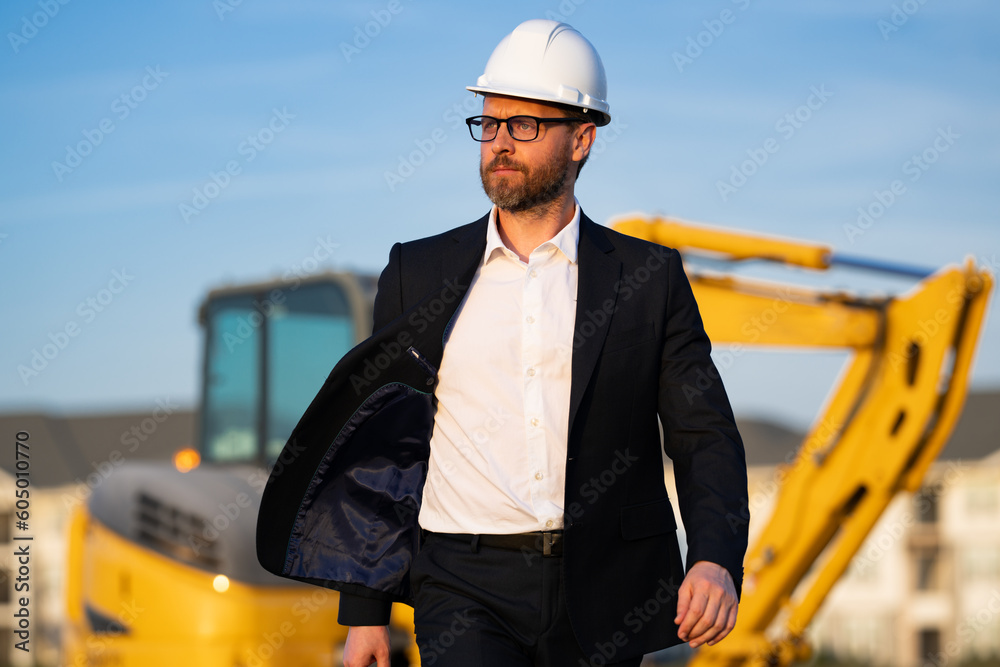 Construction owner near excavator. Confident construction owner in ...