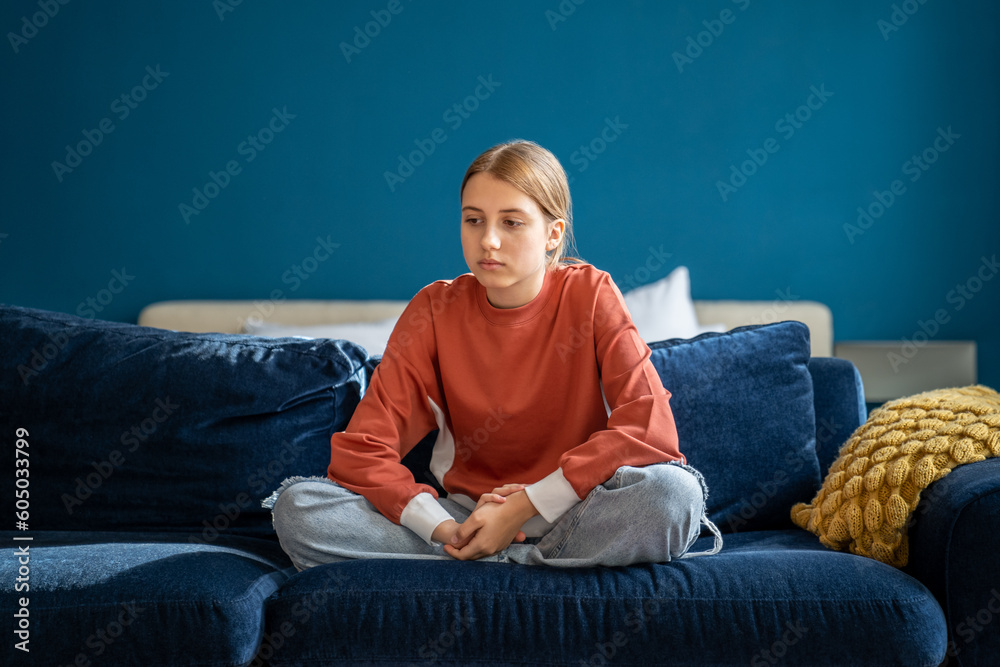 Upset moody teen girl sitting on sofa at home, being sad. Worried ...