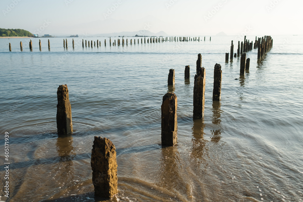 Beach with Remnants of Pier Posts Stretching Beautifully into the ...