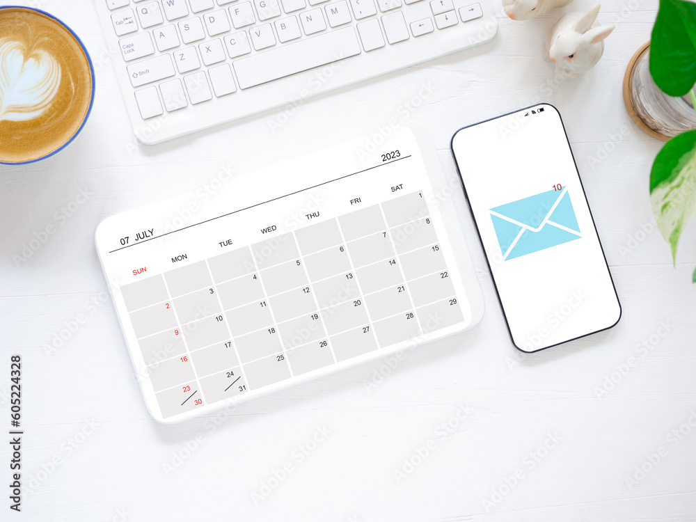 Top view, tablet computer showing July 2023 calendar app page and ...