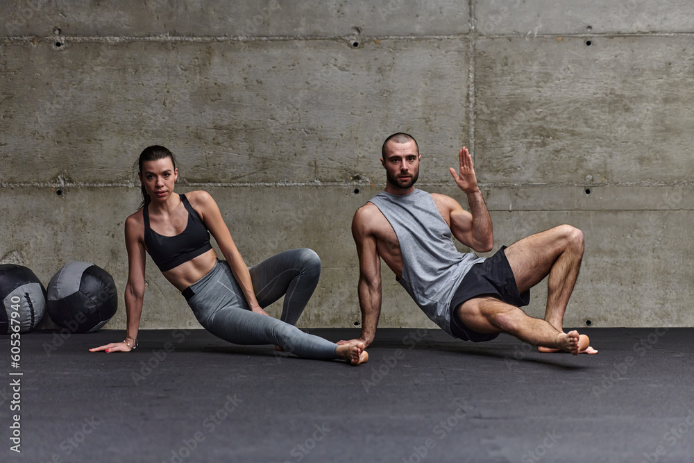 An attractive couple in the gym engaging in various stretching ...