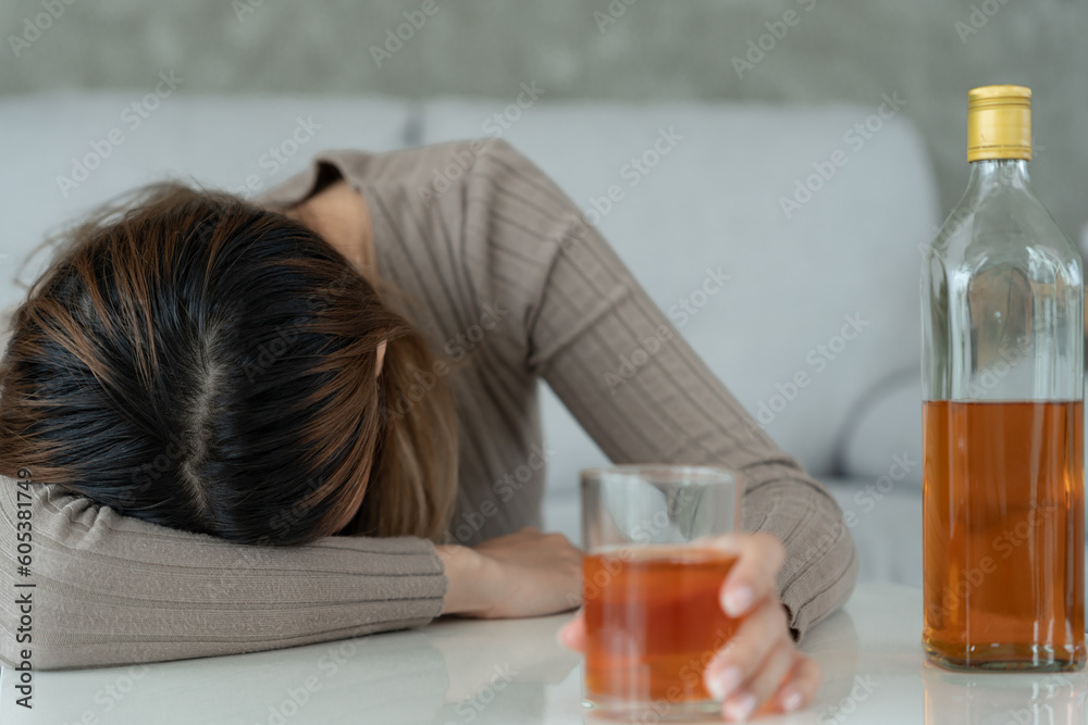 Depressed young Asian woman addicted feeling bad drinking whiskey alone ...