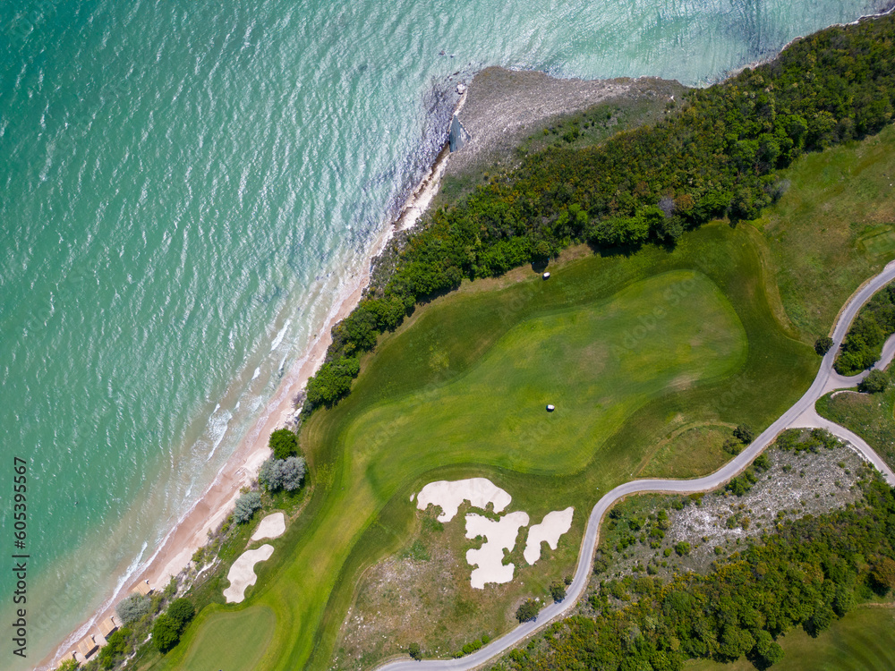 Aerial view of the golf course stretches out beneath, its lush green ...