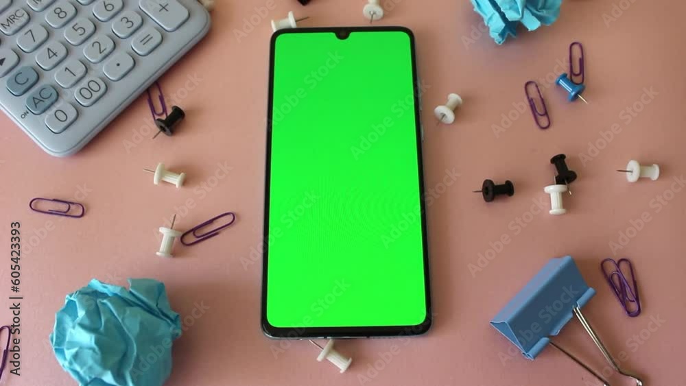 Top view, Smart phone on pink background with green screen and office ...